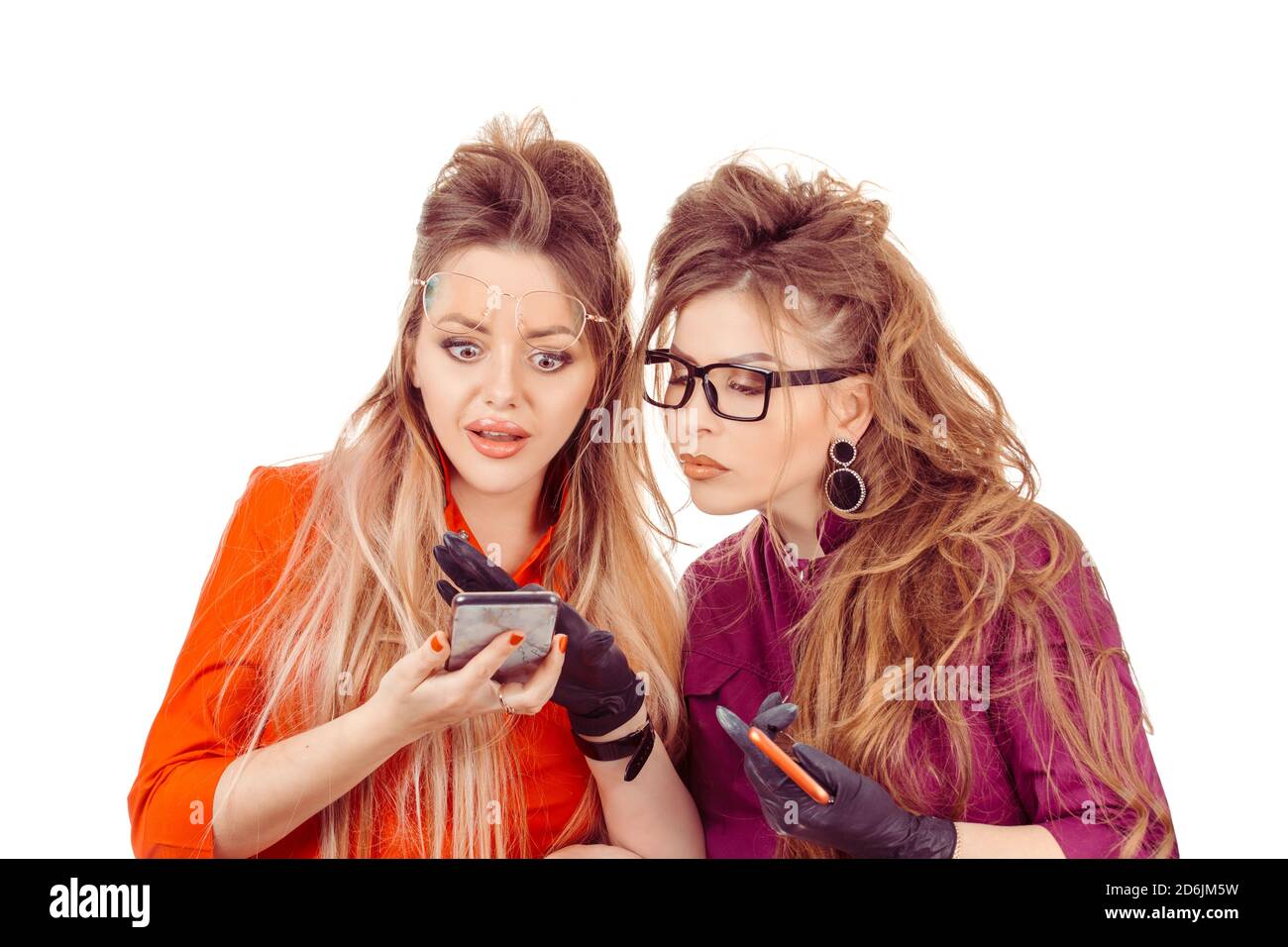 Surprised. Two shocked women young girls looking at mobile phone seeing ...