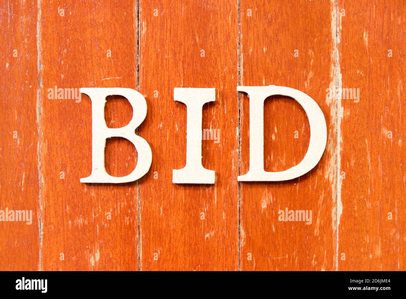 Alphabet letter in word bid on old red color wood plate background ...
