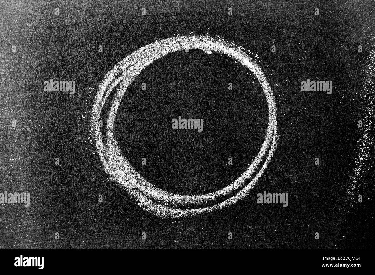 White color chalk hand drawing in circle or oval shape on black board ...