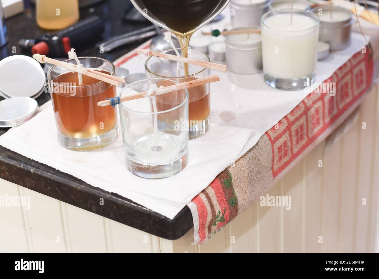 Creative occupation of candle making showing the pouring of liquid wax ...