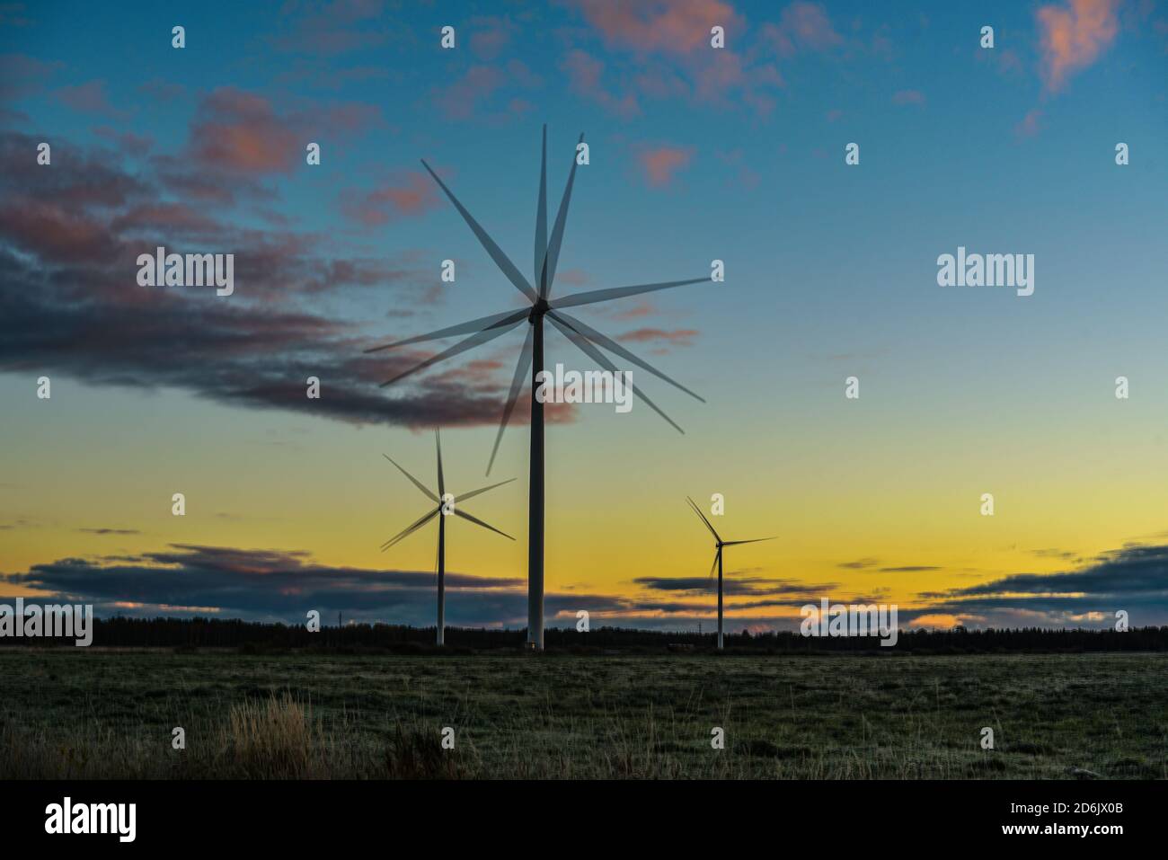 before sunrise, three moving wind generators spin and produce ...