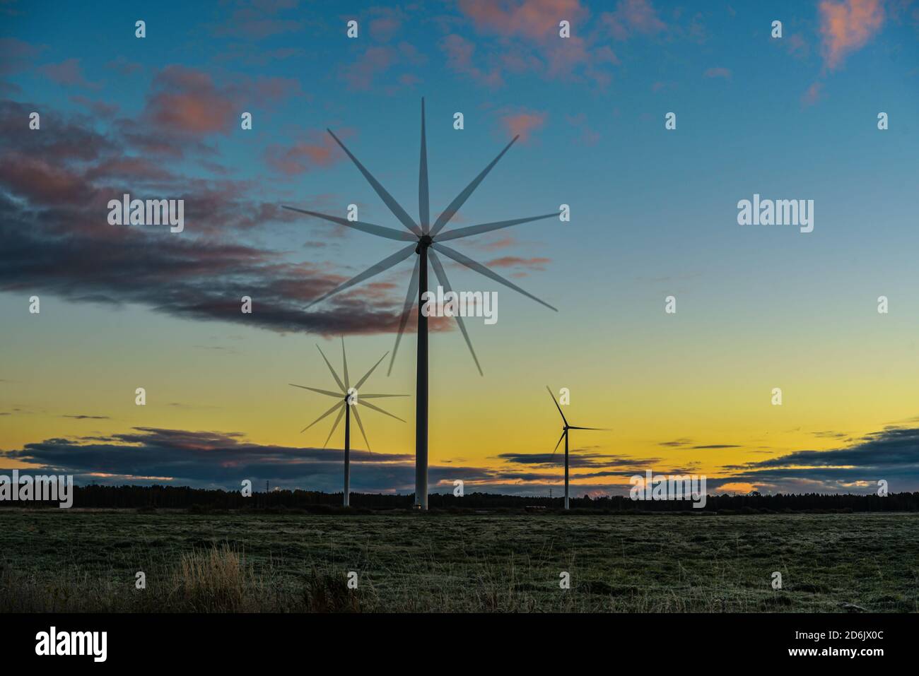 before sunrise, three moving wind generators spin and produce ...