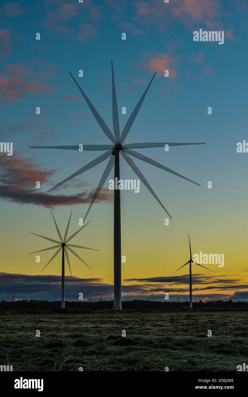 before sunrise, three moving wind generators spin and produce ...