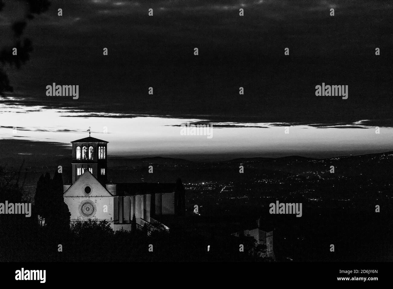 View of St. Francis papal church in Assisi at night, with city lights ...