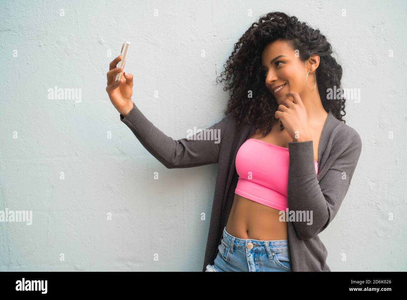 Portrait Of Afro Woman Taking Selfies With Her Mophile Phone Against