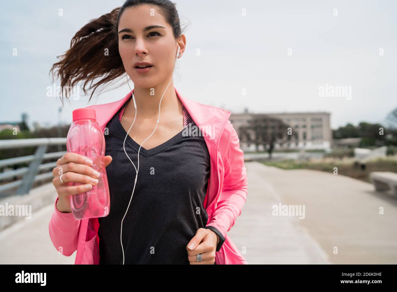 Portrait of a fitness woman running outdoors in the street. Sport and ...