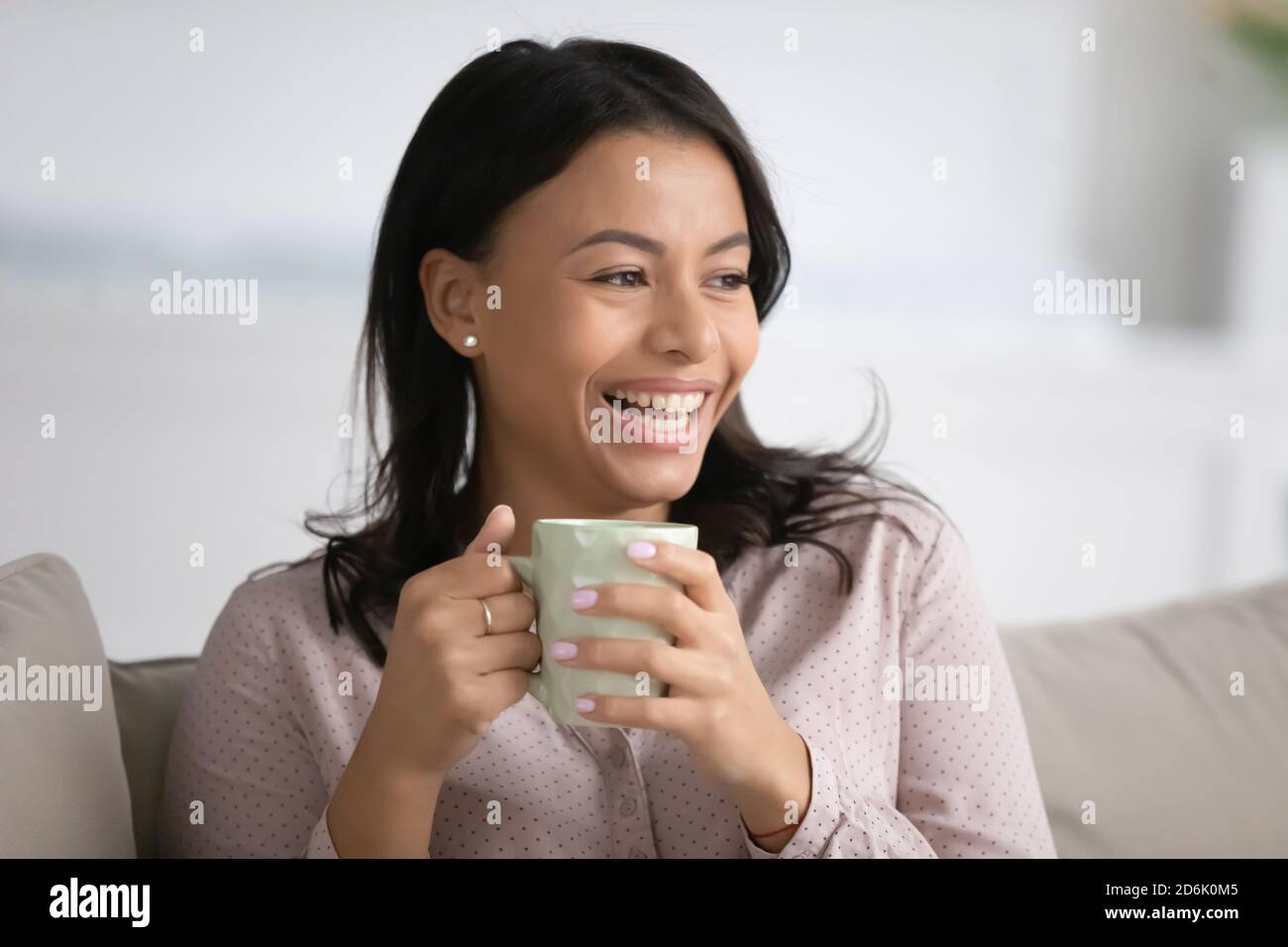 Happy biracial woman drink coffee dreaming at home Stock Photo - Alamy