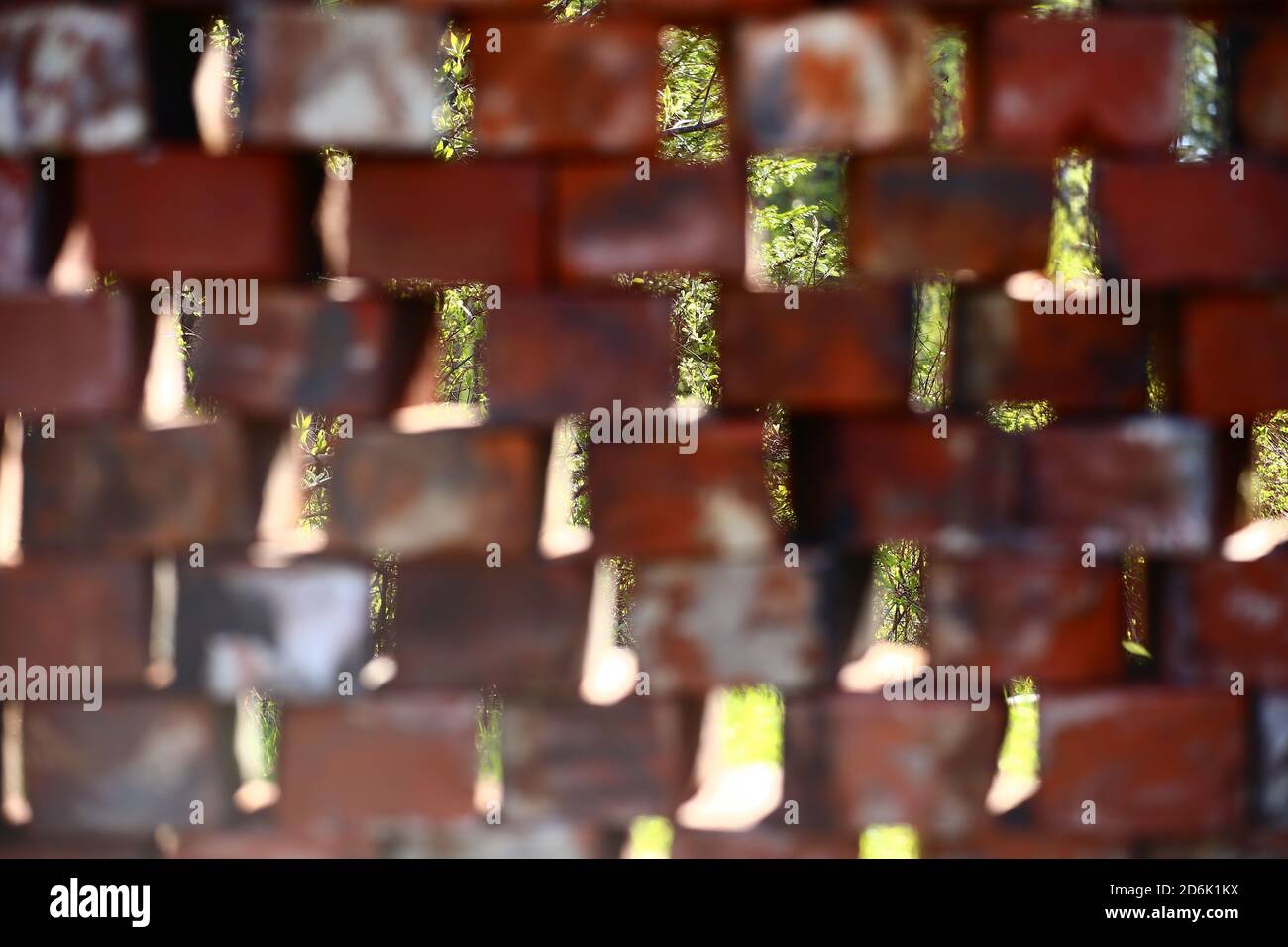 Stacked used bricks in front of a bush Stock Photo - Alamy