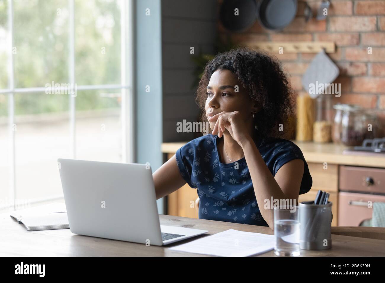 Pensive African American woman work on laptop thinking Stock Photo - Alamy