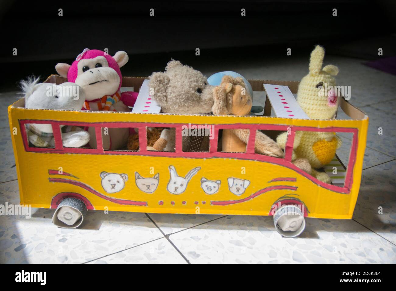 Homemade bus for kids, made of cardboard, painted yellow, with dolls as ...