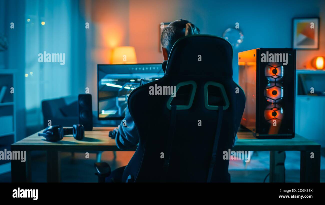 Back Shot of a Gamer Playing First-Person Shooter Online Video Game on ...