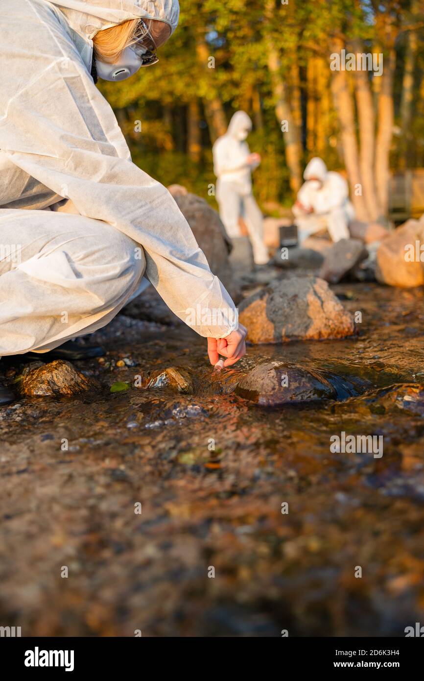 Female scientist in team collecting water sample from sea Stock Photo ...
