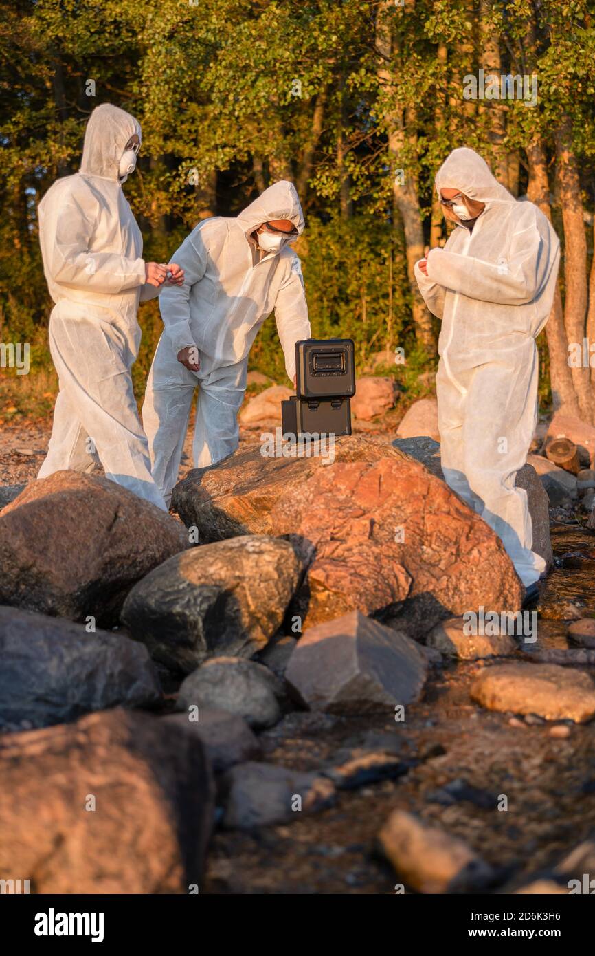 Researchers in team with container at beach taking water samples Stock ...