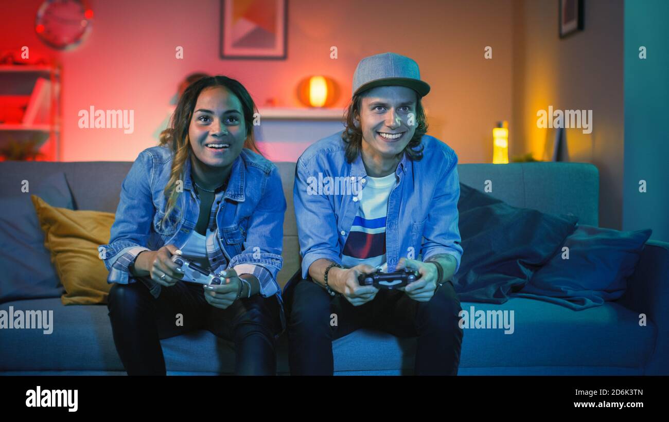 Excited Black Gamer Girl and Young Man Sitting on a Couch and Playing ...