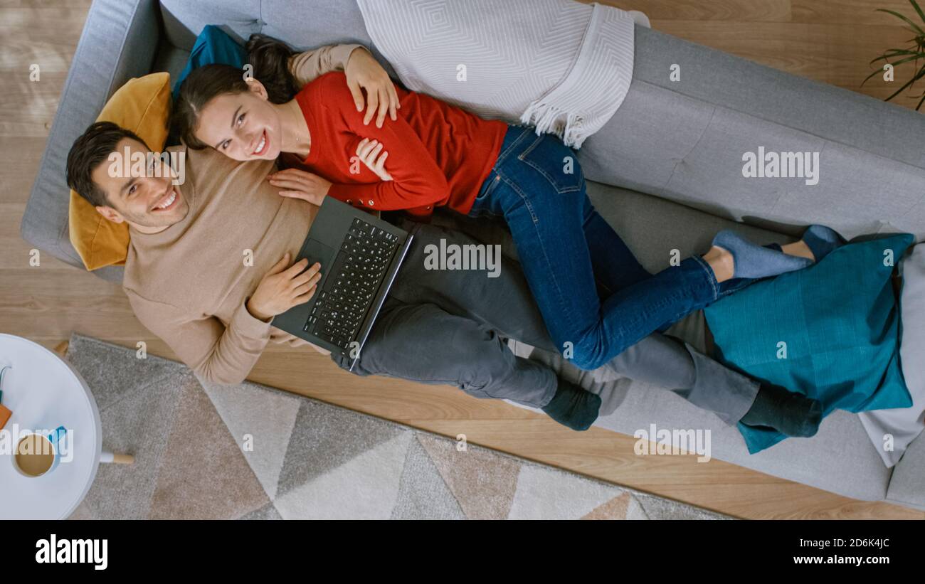 Young Beautiful Couple is Lying Down on a Sofa. Man is Gently Hugging ...