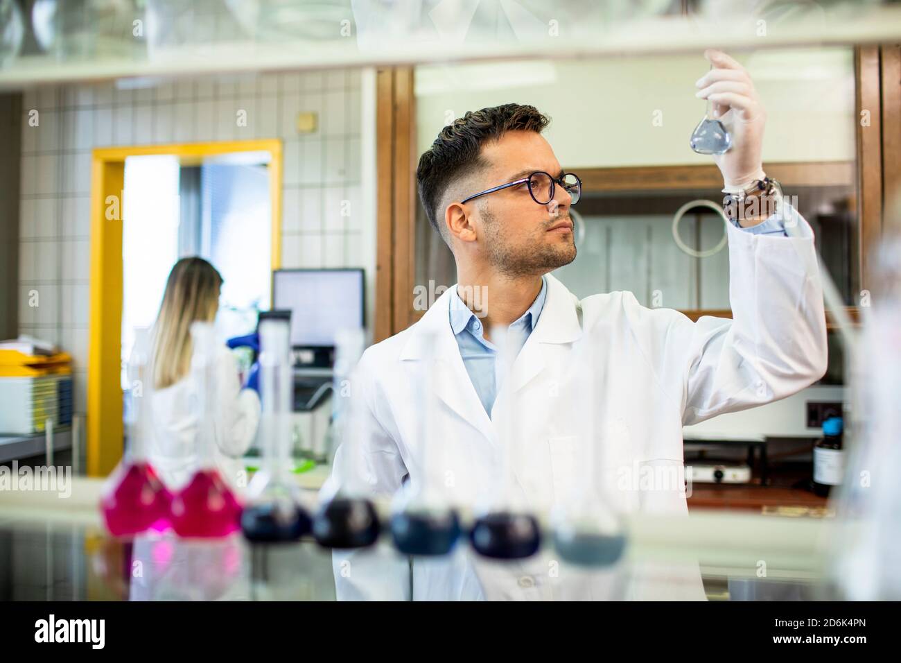 Young researcher checking test tubes in the laboratory Stock Photo - Alamy