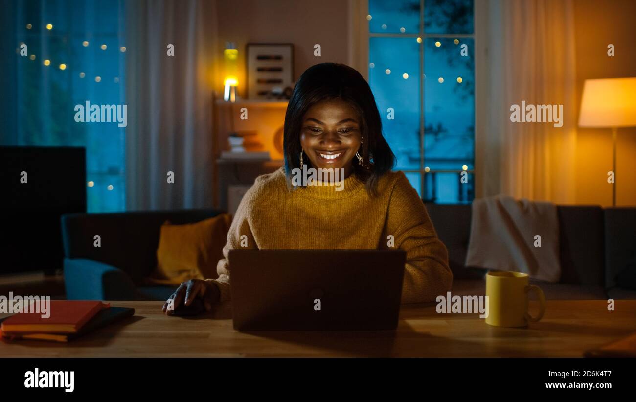 Portrait of Beautiful Smiling Black Girl Working on a Laptop while Sitting at Her Desk at Home ...