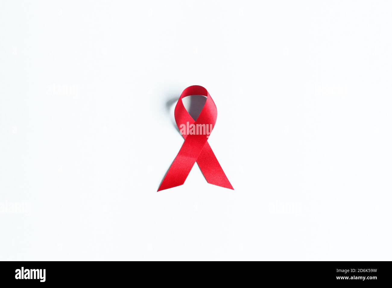 red AIDS awareness ribbon on the white paper background. World aids day ...