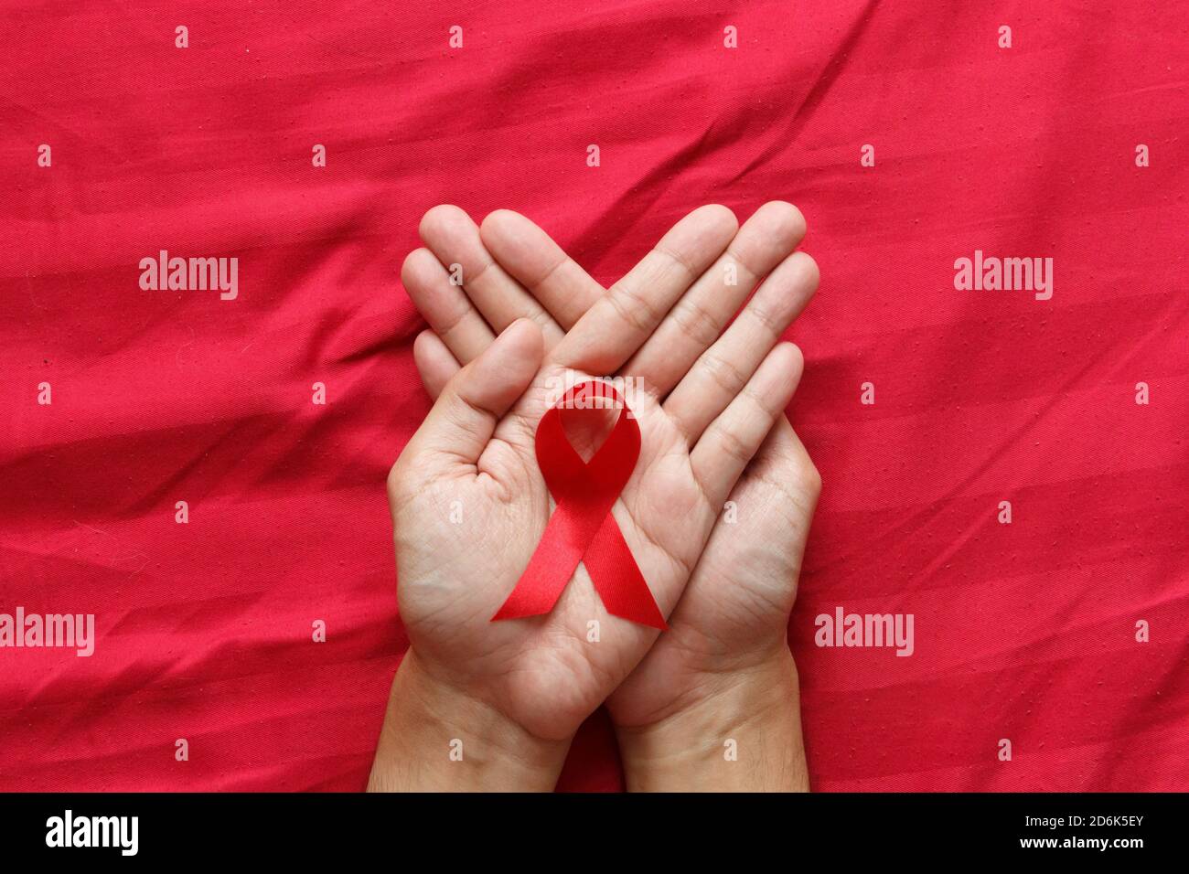 red AIDS awareness ribbon on the hand. World aids day and healthcare ...