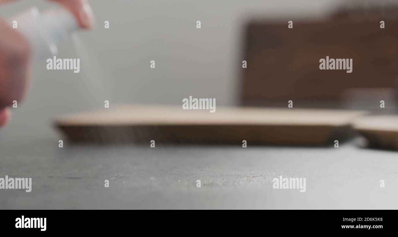 closeup man sanitizing concrete countertop, wide photo Stock Photo - Alamy