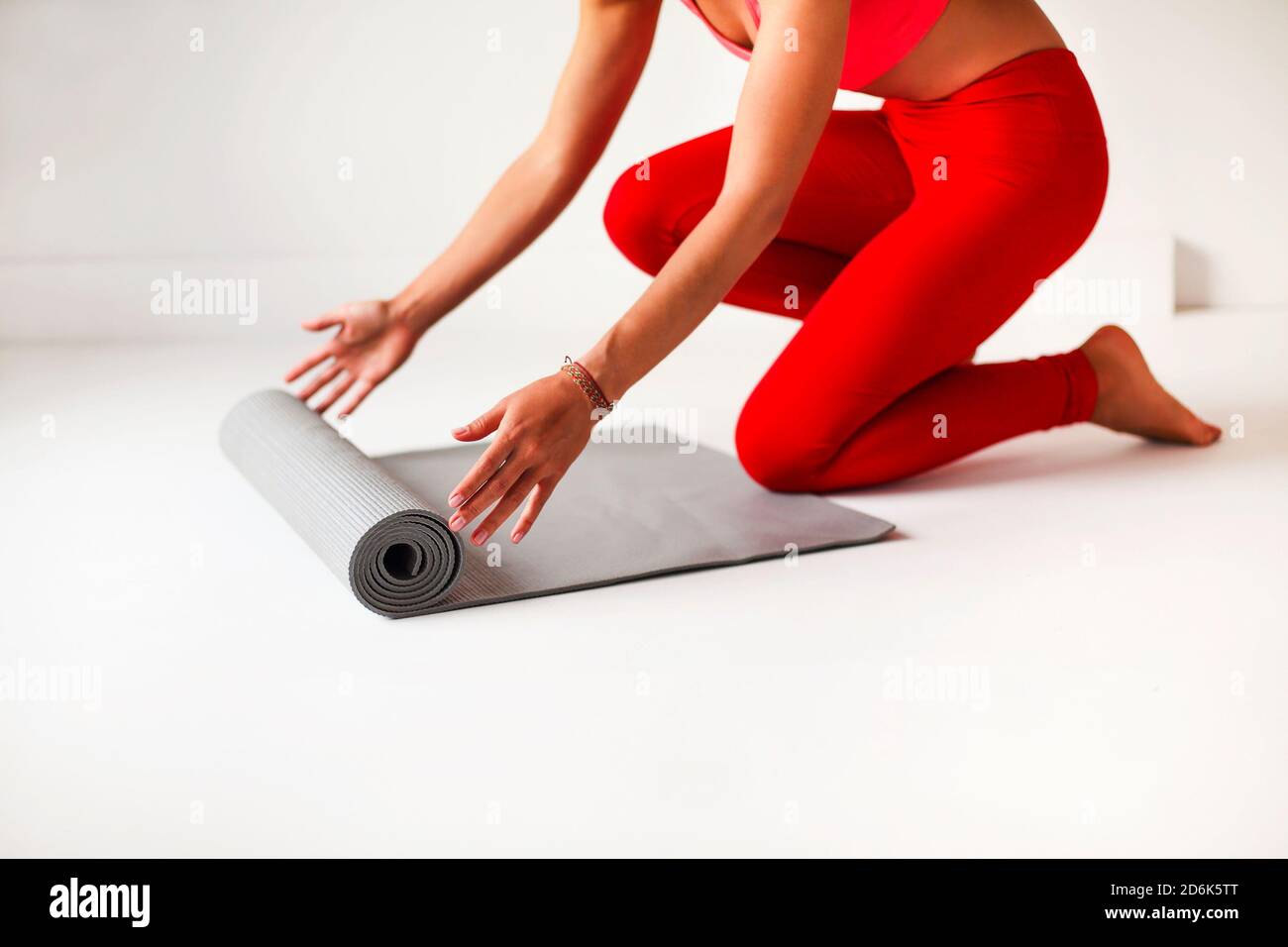 Side view of crop anonymous slim female in bright red top and leggings ...