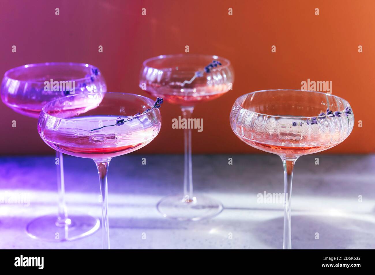 Set of glass goblets with champagne and flowers placed on table in ...