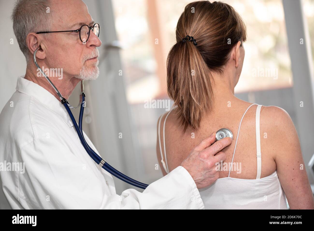 Senior doctor auscultating his female patient with stethoscope Stock ...