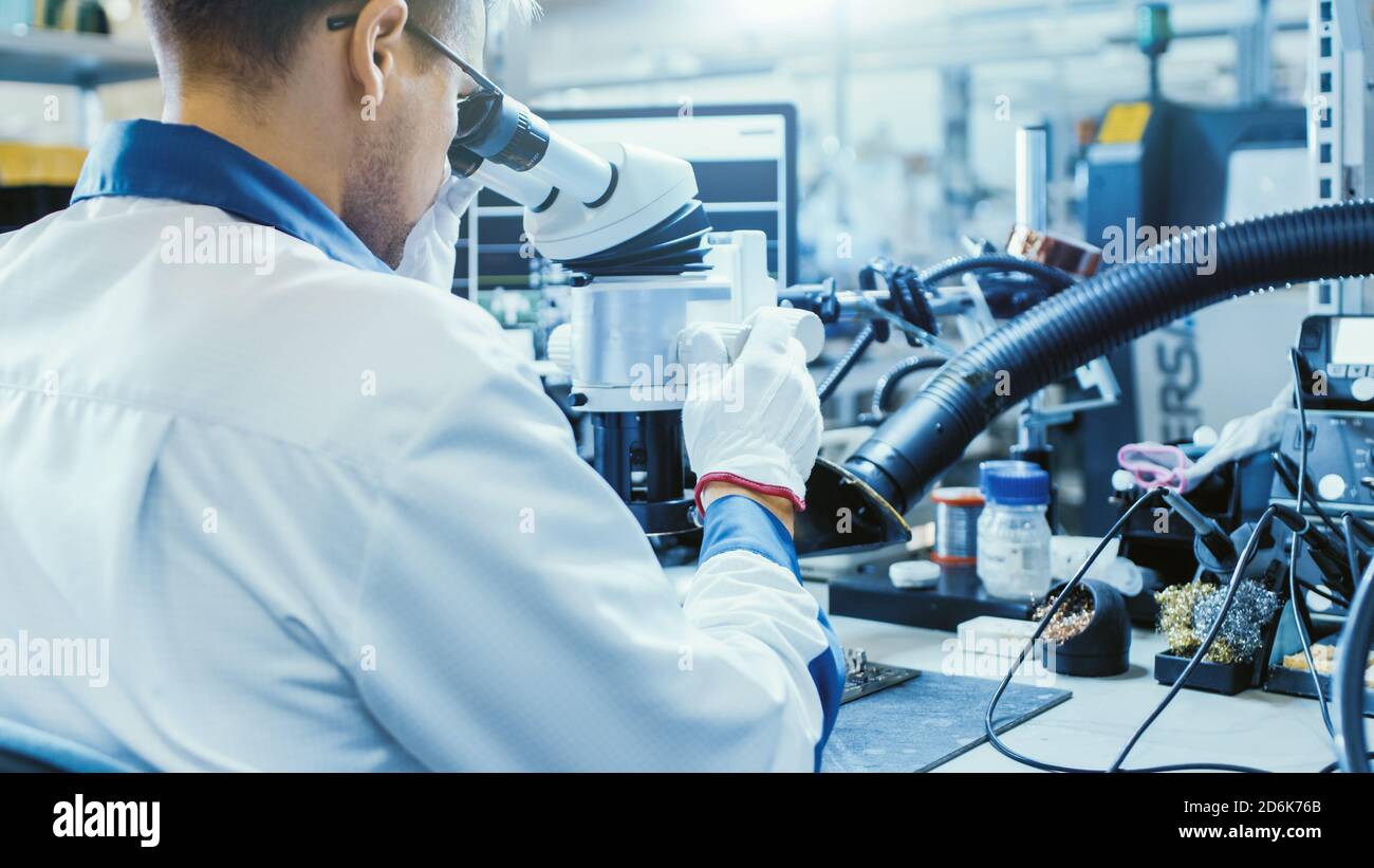 Electronics Factory Worker in White Work Coat is Soldering a Printed ...