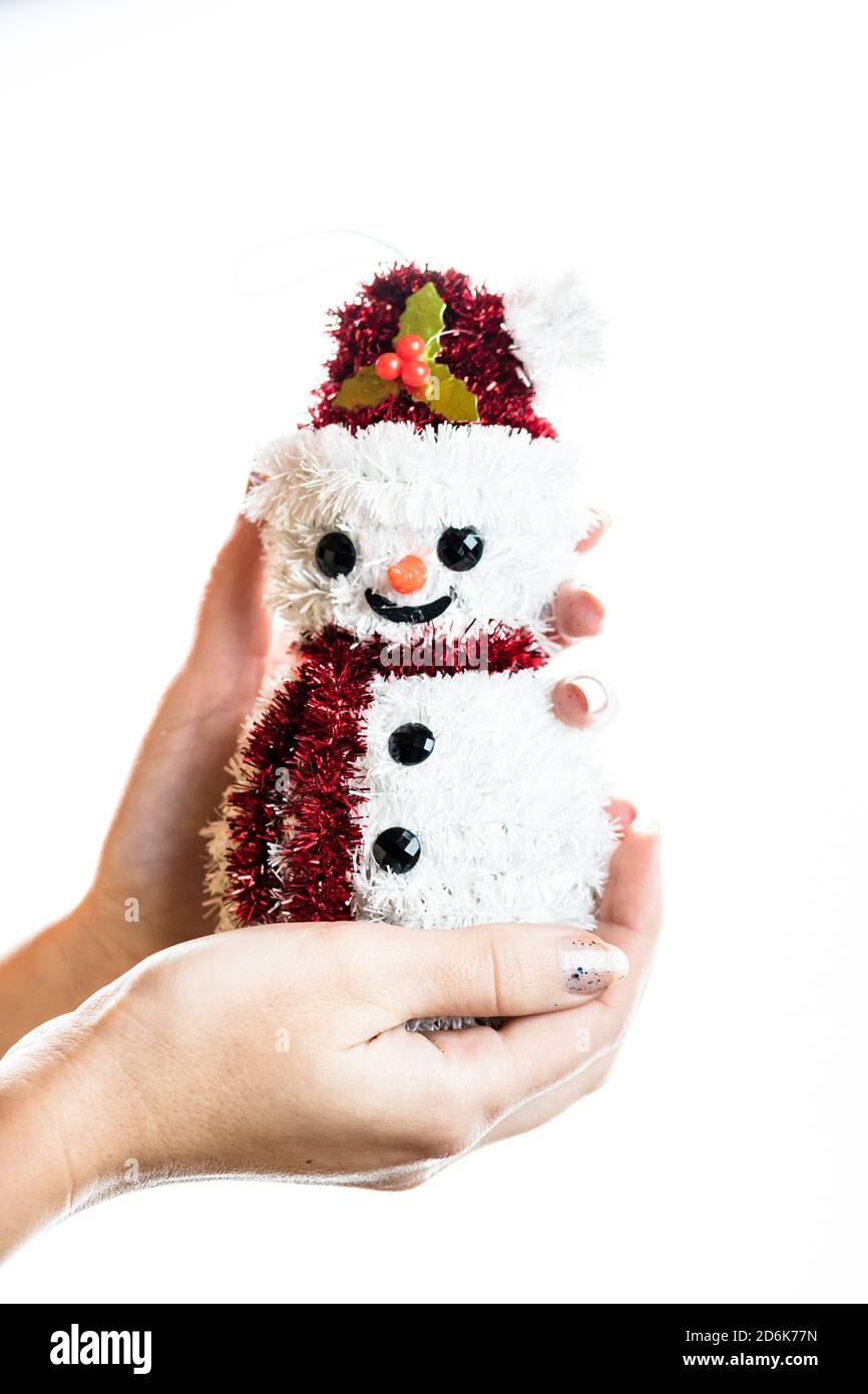 Hand holding Christmas snowman figurine isolated on white background ...