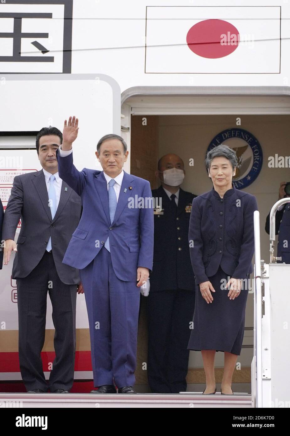 Japanese Prime Minister Yoshihide Suga (2nd from L) waves before ...
