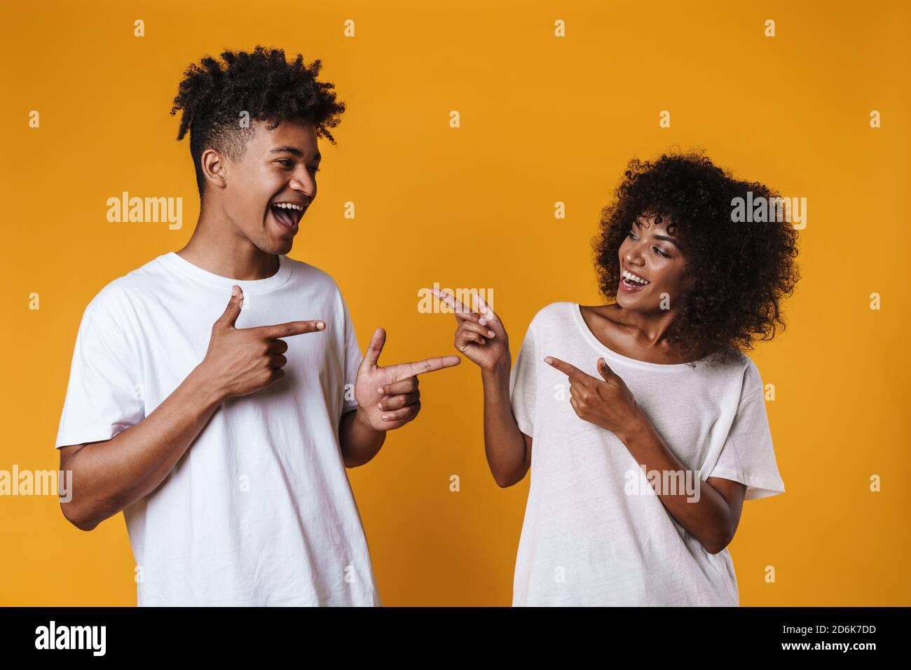 Image of joyful african american couple pointing fingers at each other ...
