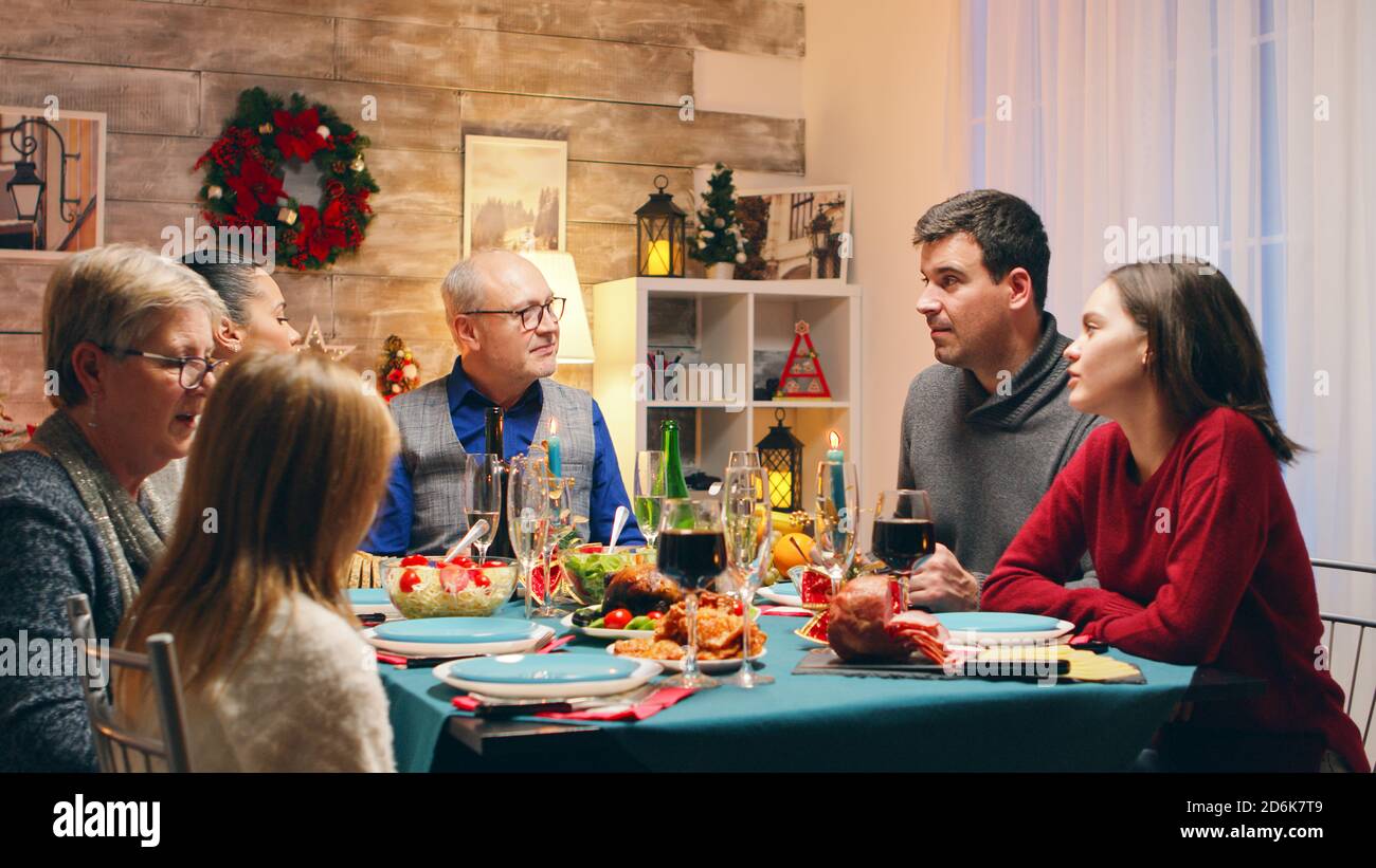Grandmother talking with little granddaughter at christmas reunion ...