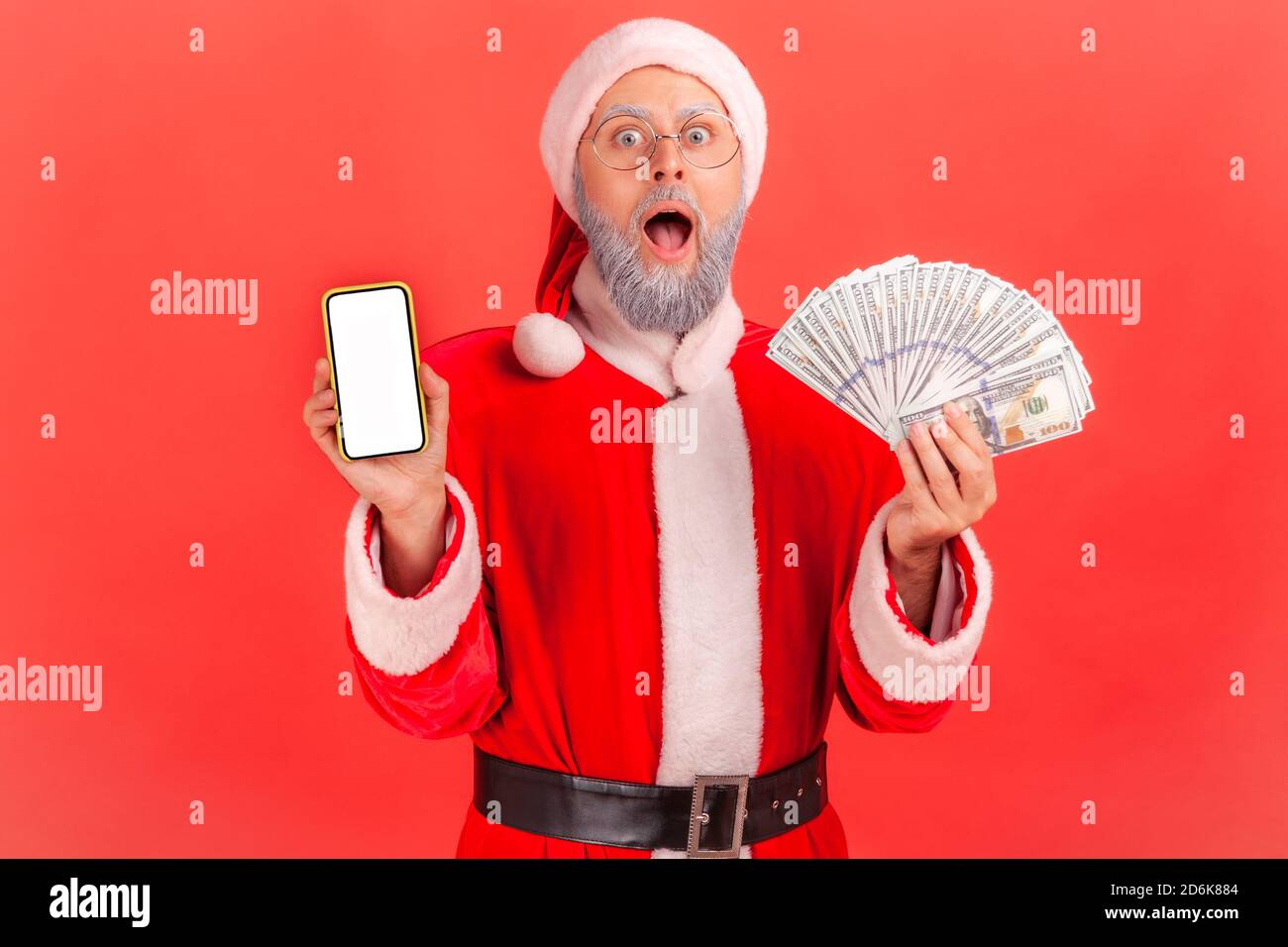 Shocked excited gray bearded man in santa claus costume holding fan of ...