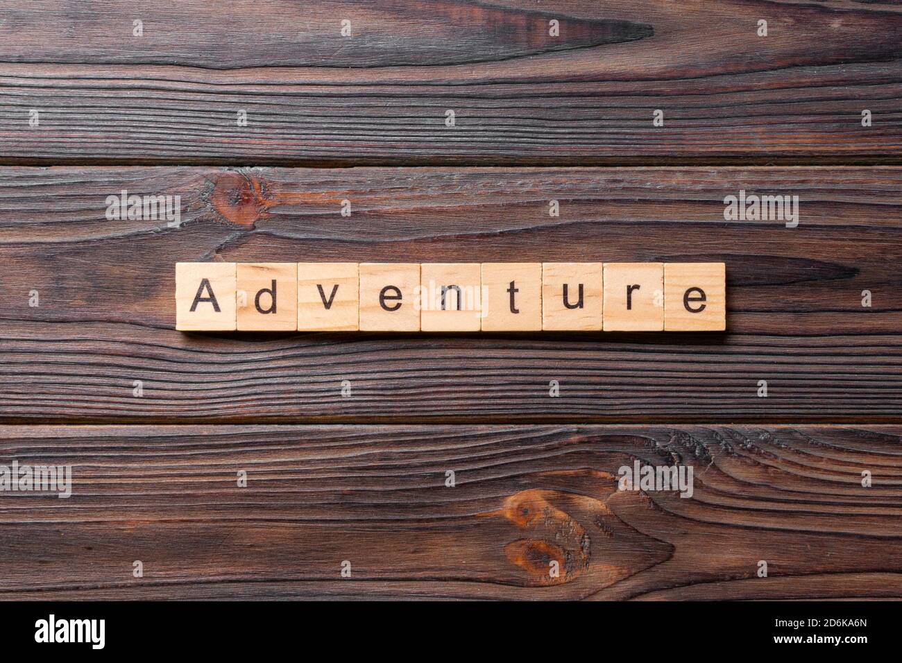 adventure word written on wood block. adventure text on cement table ...