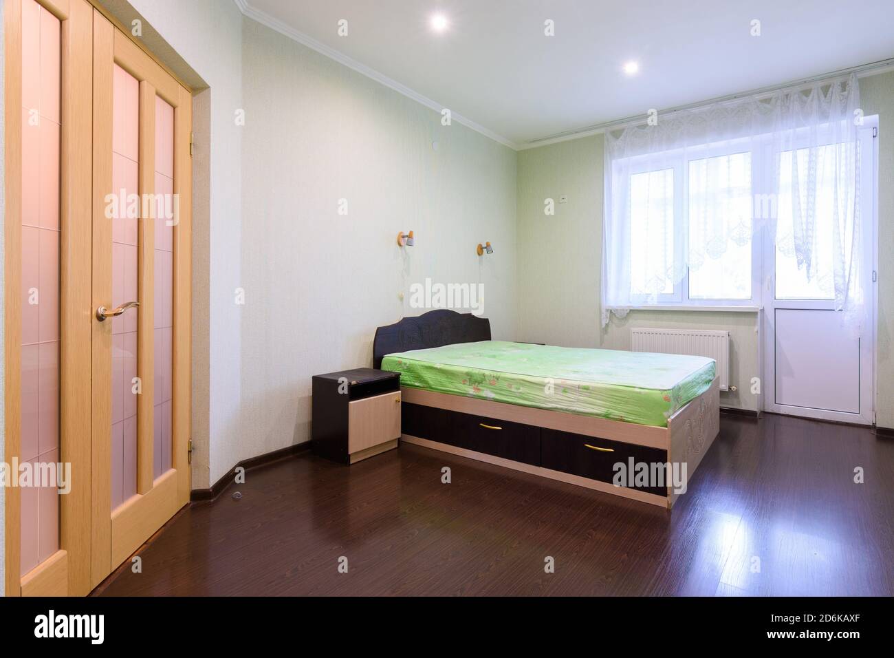 Bedroom interior with a bed in the middle and a large window opening ...