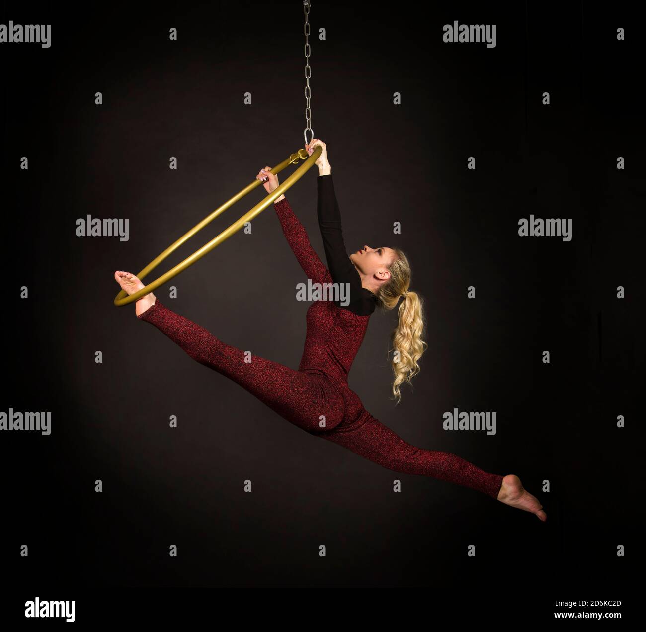 A slender blonde woman-an air acrobat in a red suit with long hair ...