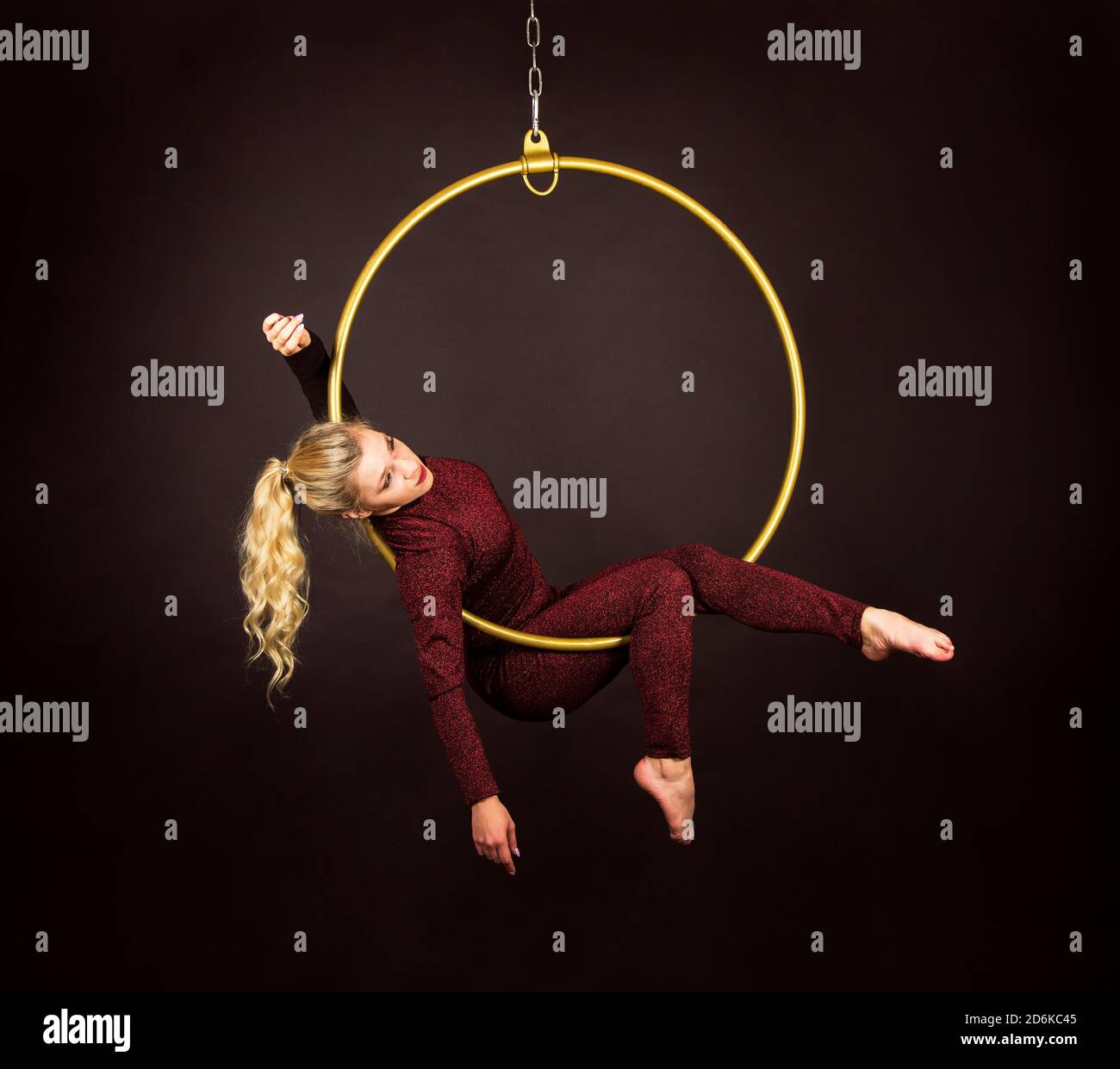 A slender blonde woman-an air acrobat in a red suit with long hair ...