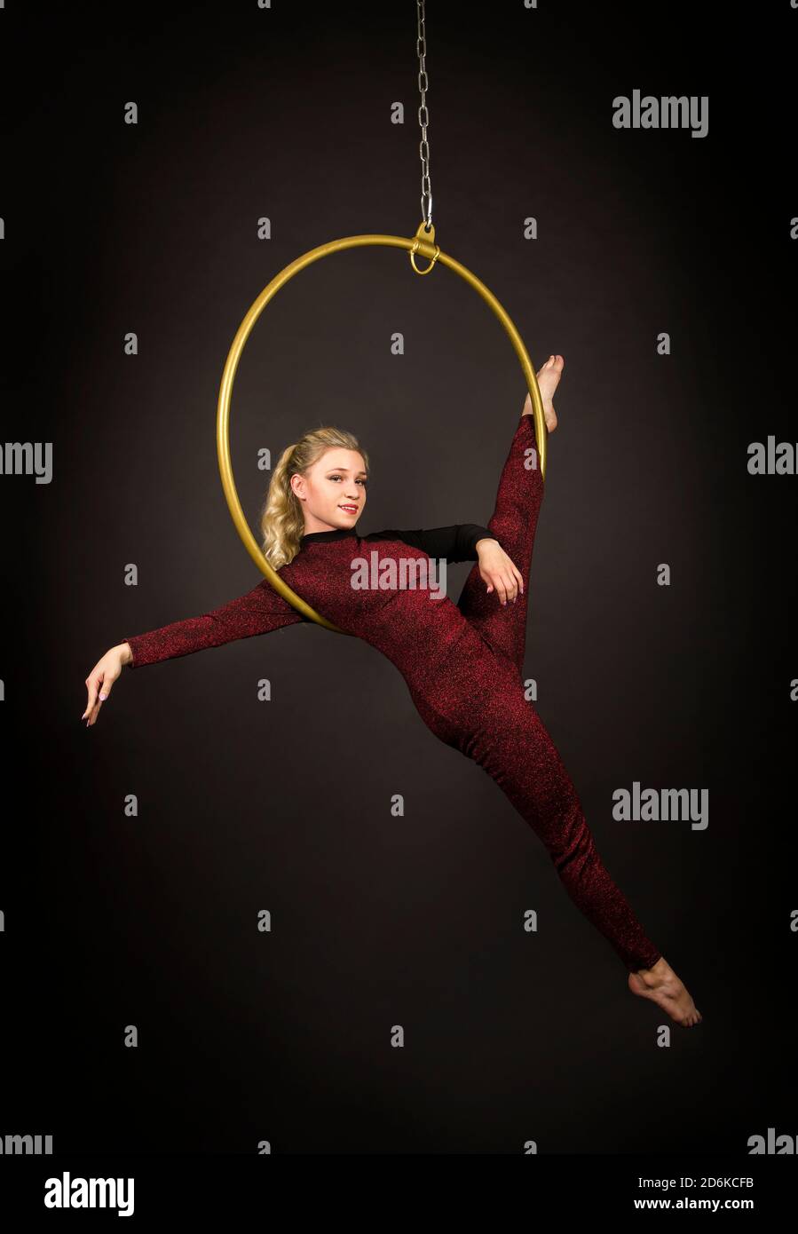 A slender blonde woman-an air acrobat in a red suit with long hair ...