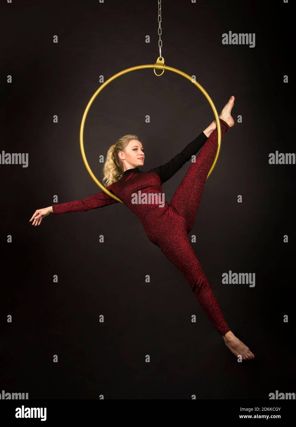 A slender blonde woman-an air acrobat in a red suit with long hair ...