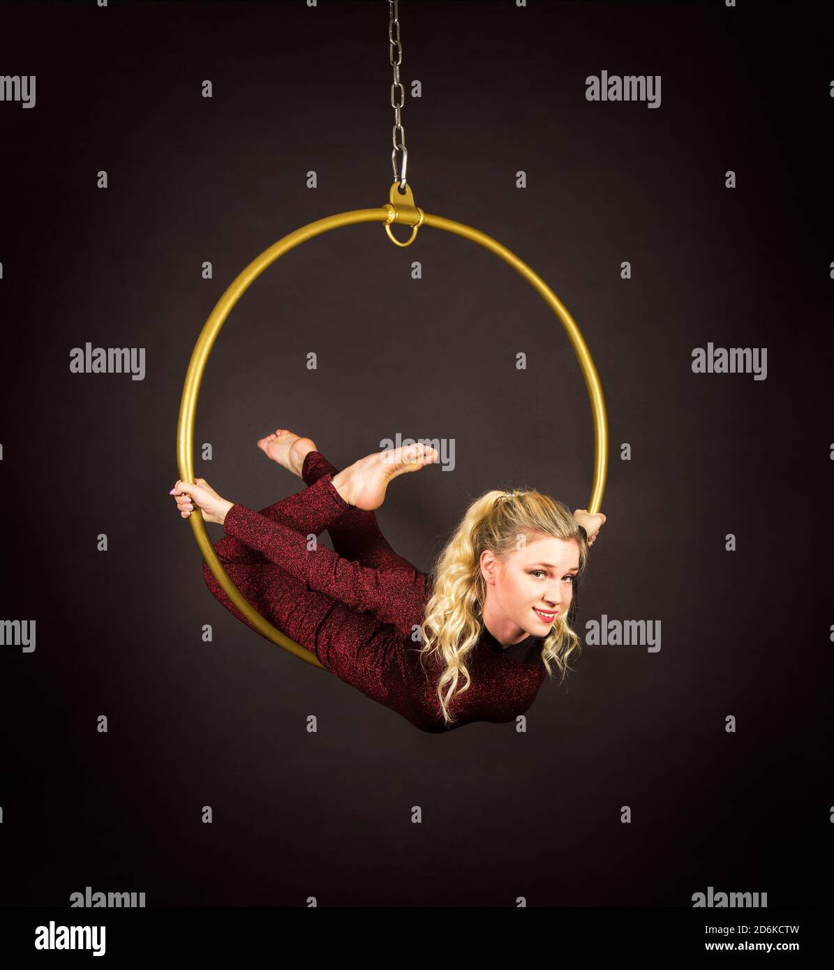 A slender blonde woman-an air acrobat in a red suit with long hair ...