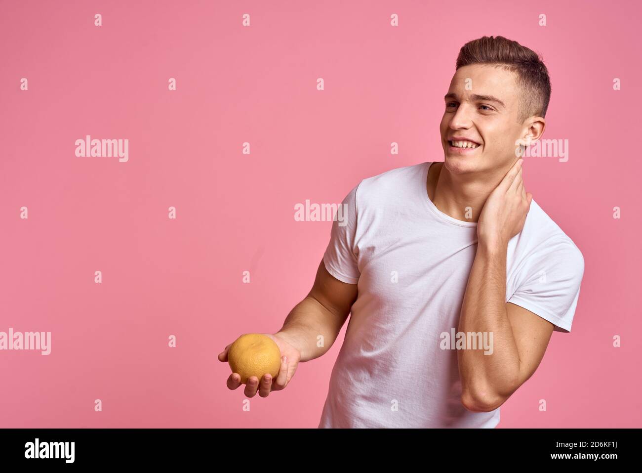 Man with fruits in hands on a pink background healthy food vitamins ...