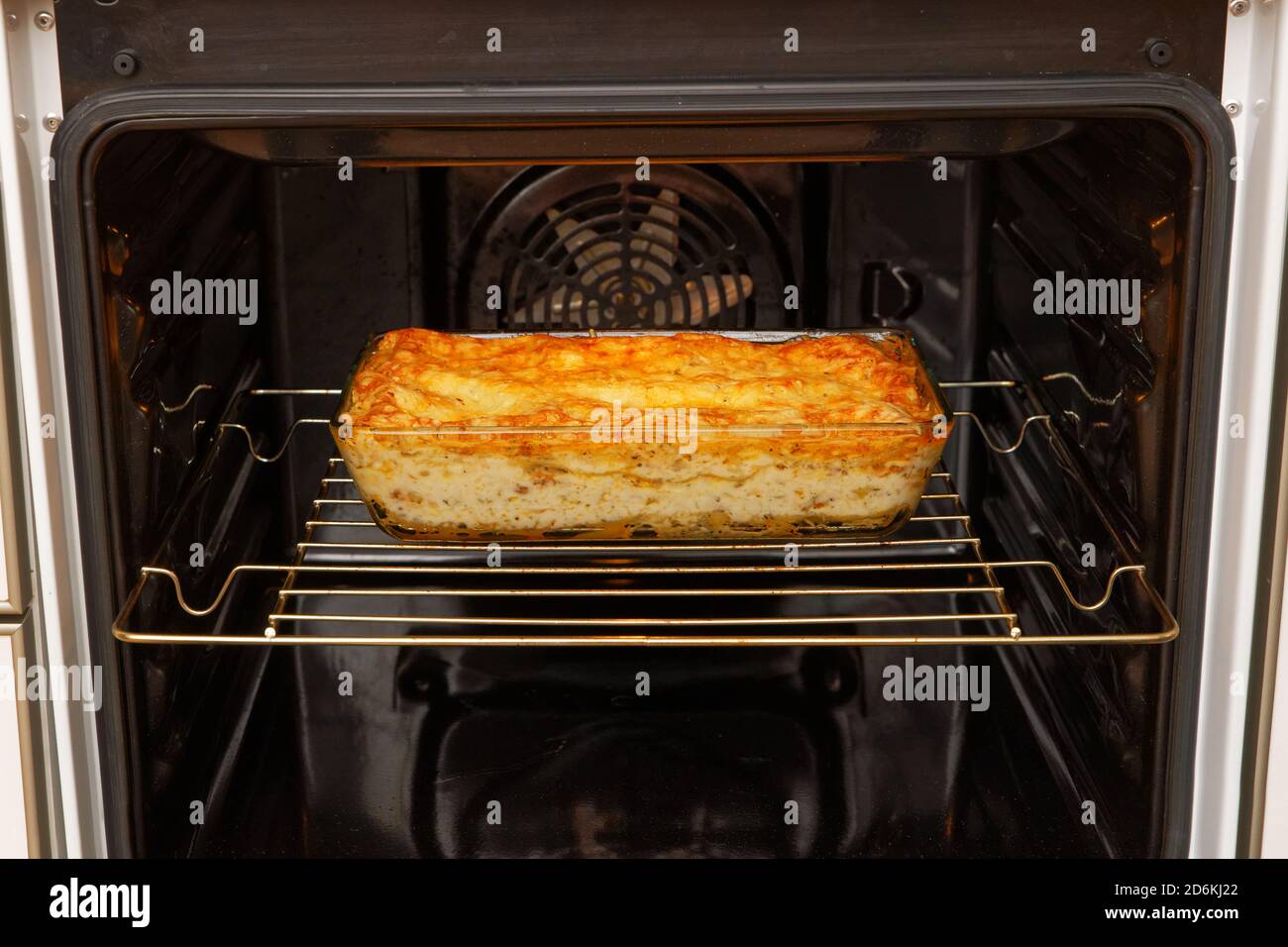 Homemade lasagna in a transparent glass form cooked in the oven on home ...