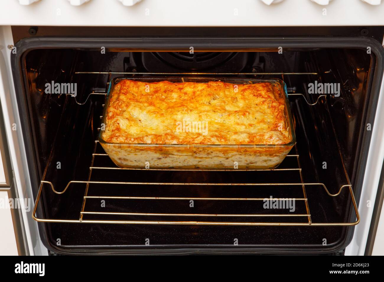 Homemade lasagna in a transparent glass form cooked in the oven on home ...