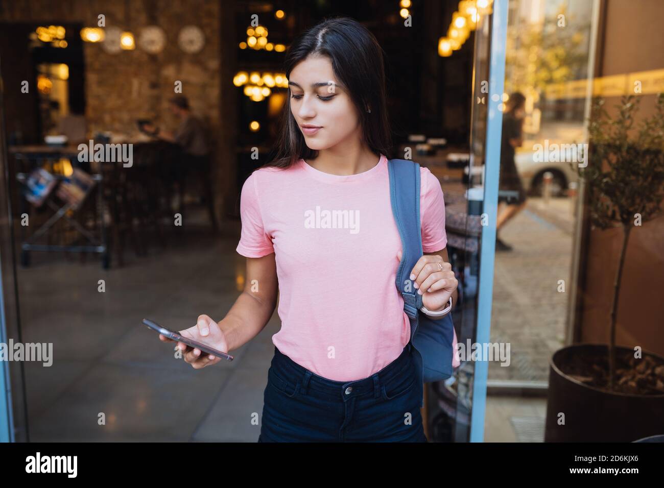 Caucasian attractive young woman walking out the door of a cafe Stock ...