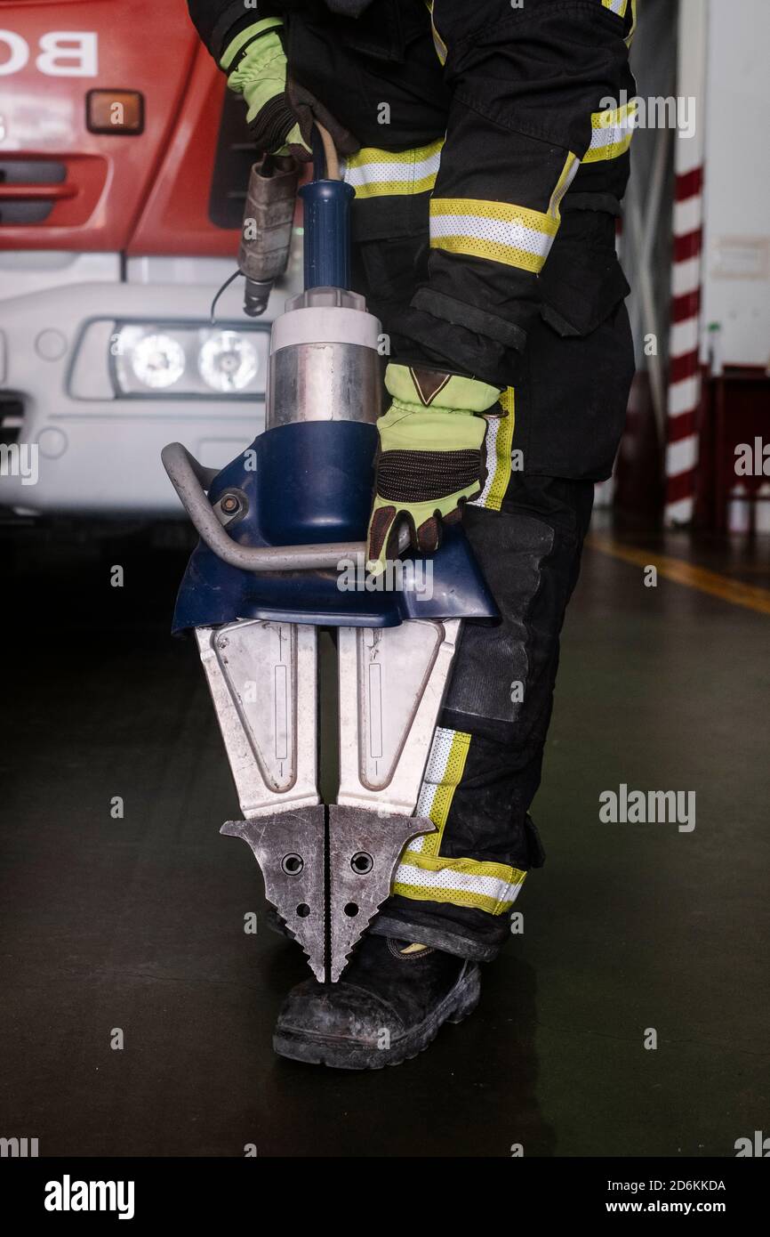 fireman holding a pair of pneumatic scissors in a fire station Stock ...