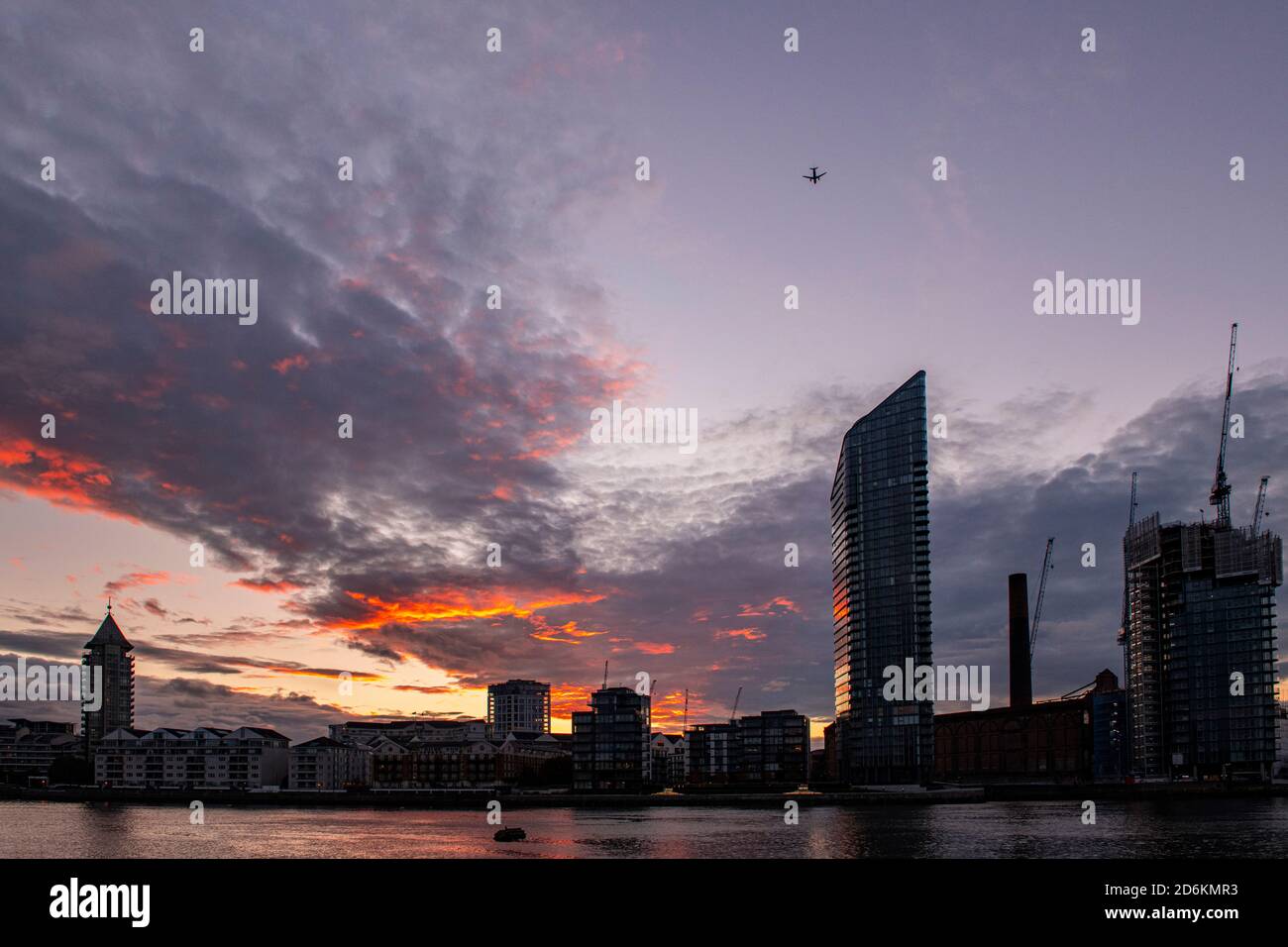 An aeroplane flies over the Chelsea skyline on the River Thames at ...