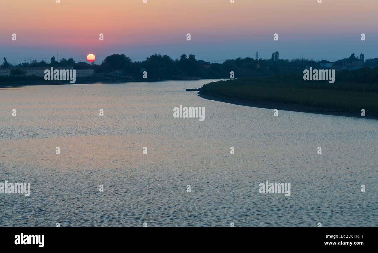 The Kura river flowing through the city of Neftechala at sunset Stock ...