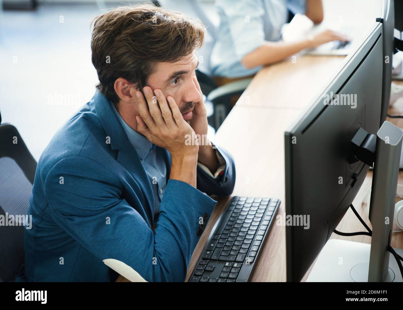 Young exhausted business man with problems and stress in the office ...