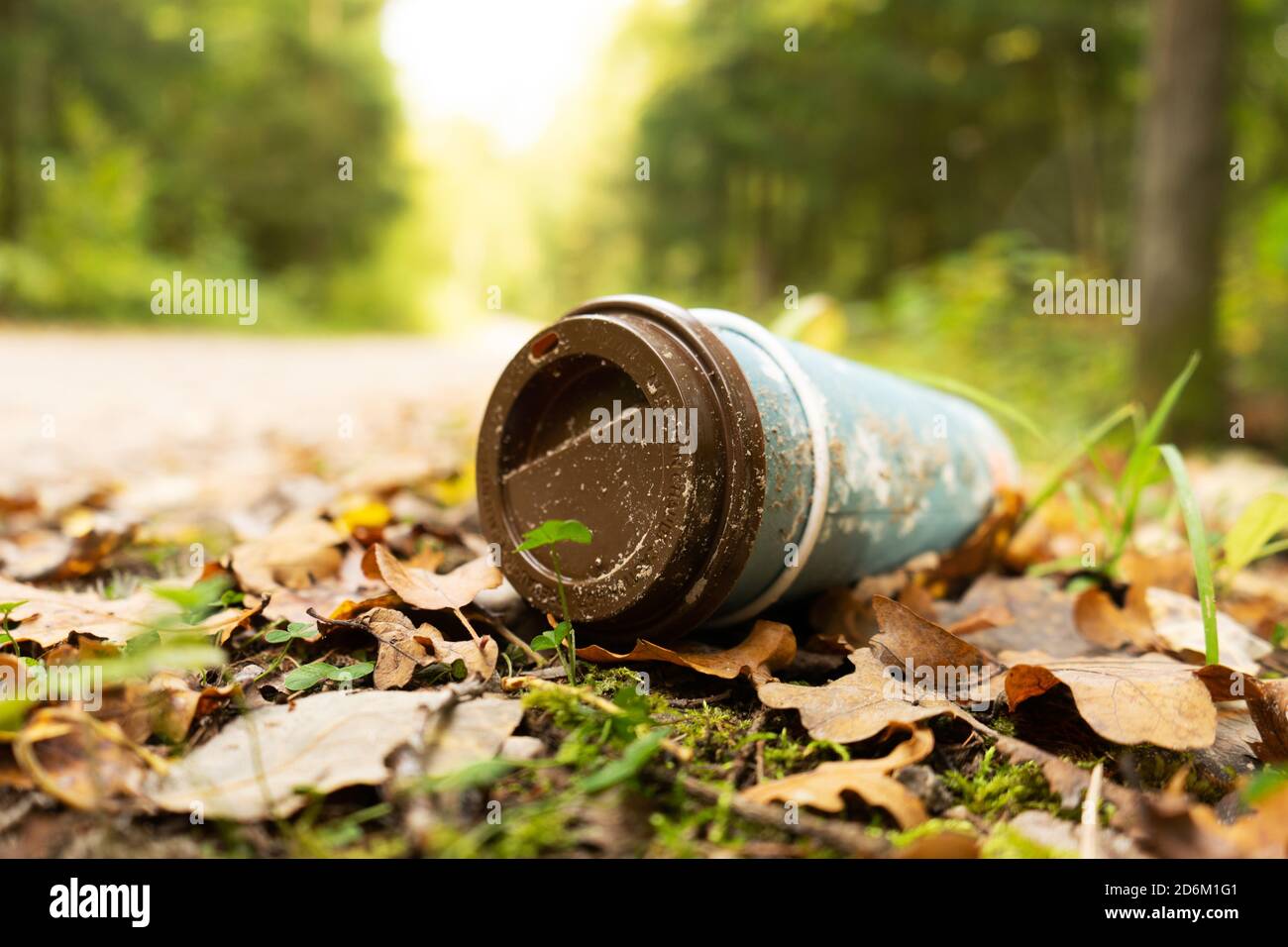 Old disposable coffee cup in the forest. Plastic recycling, pollution ...