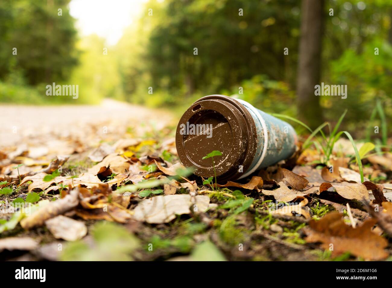 Old disposable coffee cup in the forest. Plastic recycling, pollution ...